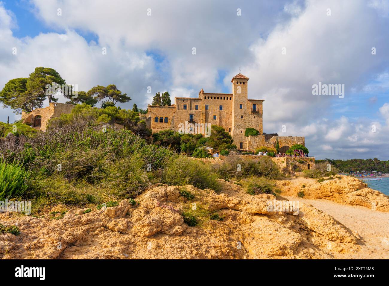 Tamarit Castle stands proudly amid lush green vegetation and rugged ...