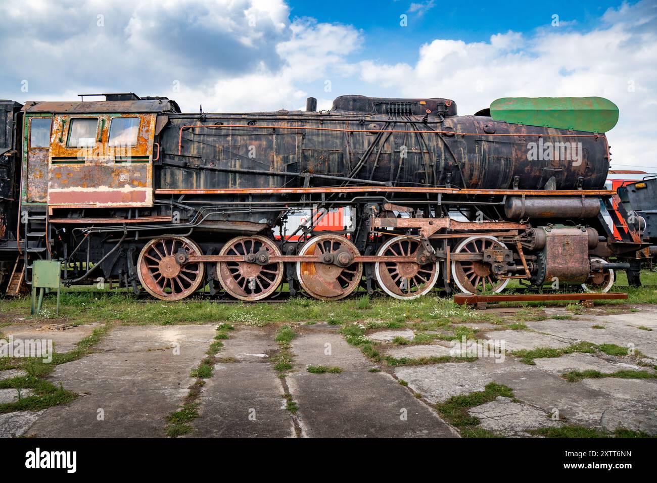 Details of an old rusty steam train resting in a yard under a cloudy ...