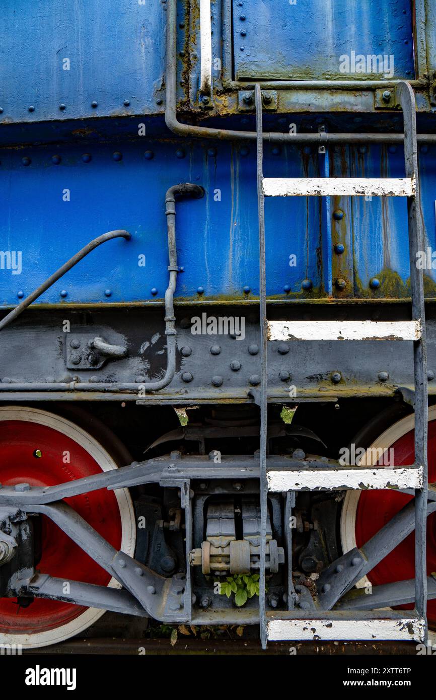 Detail view of an old rusty steam train faded blue exterior and vibrant ...