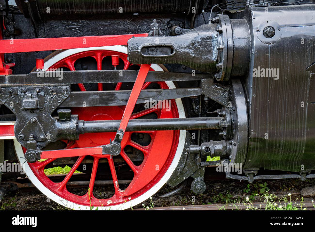 Detailed view of an old rusty steam train engine with red wheels and ...