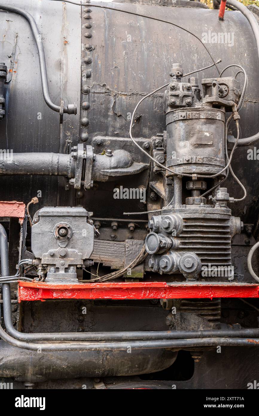 Detail of an old rusty steam train engine with intricate machinery and ...