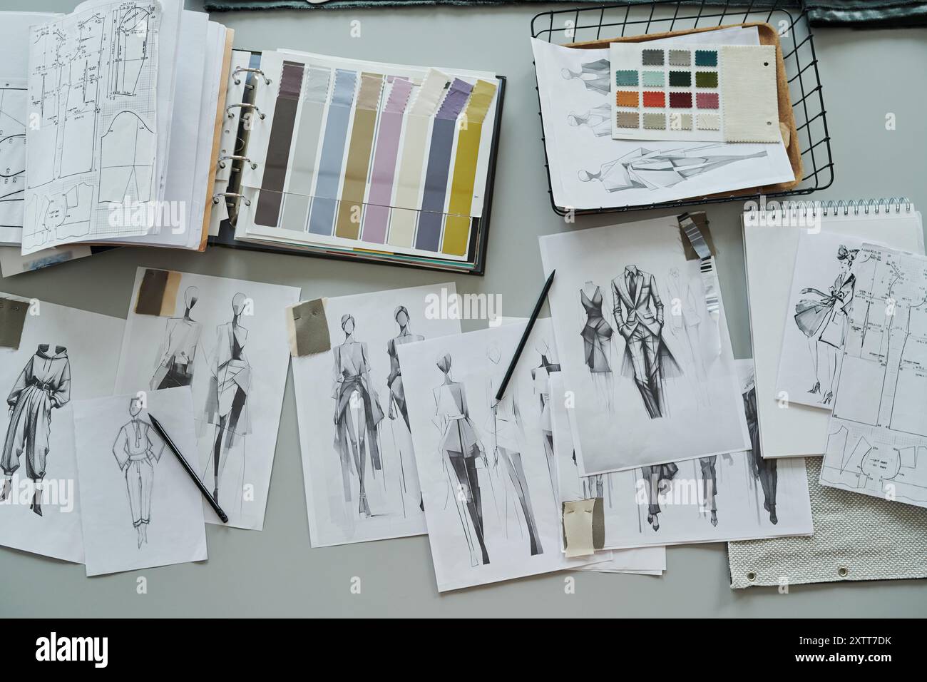 Top view of variety of drawn sketches of new trendy attire and sewing ...