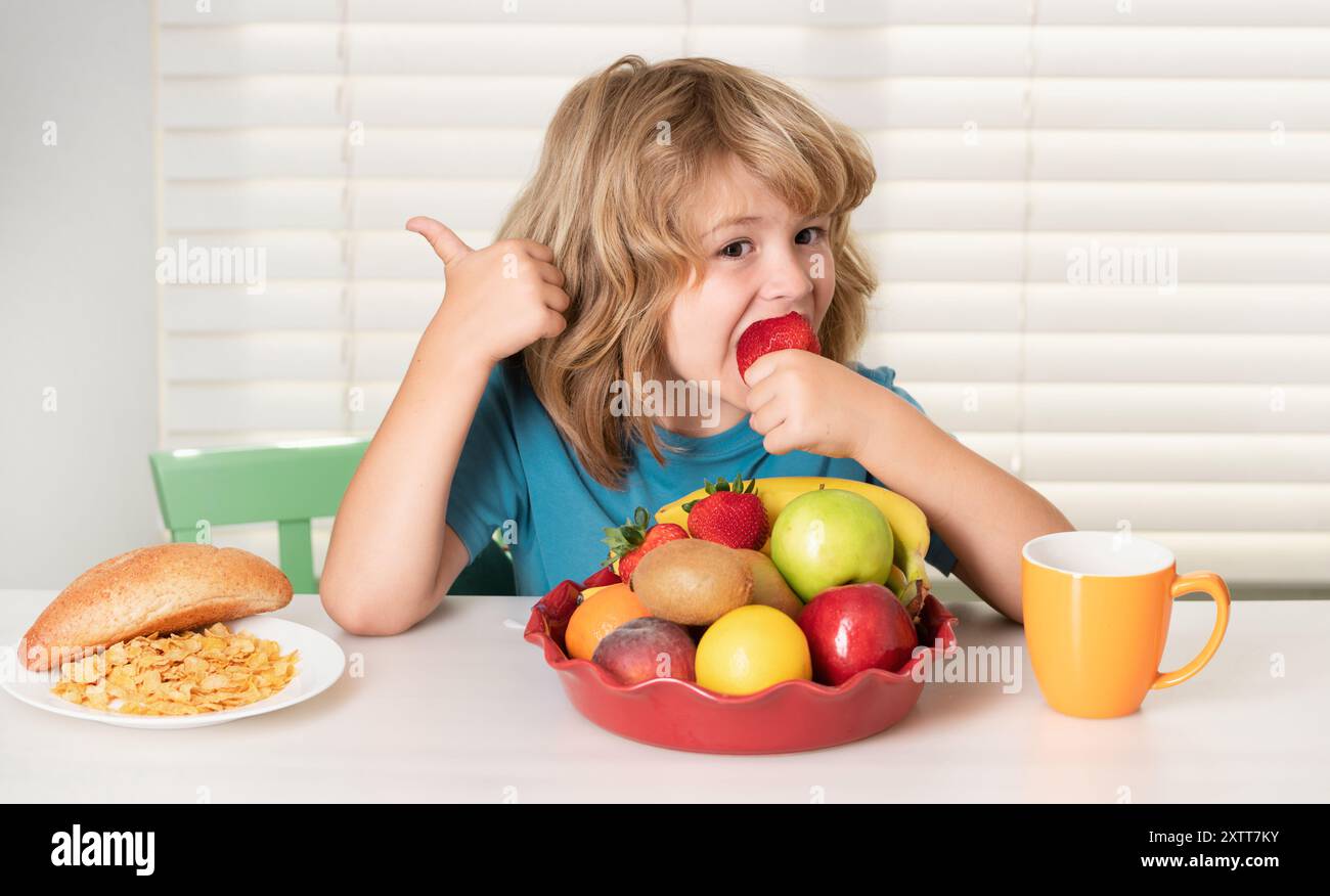 Child with strawberry, summer fruits. Child eating meal. Healthy ...