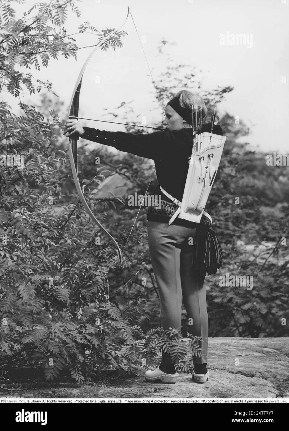 Archery 1964. A young woman is aiming with her bow and arrow Stock ...