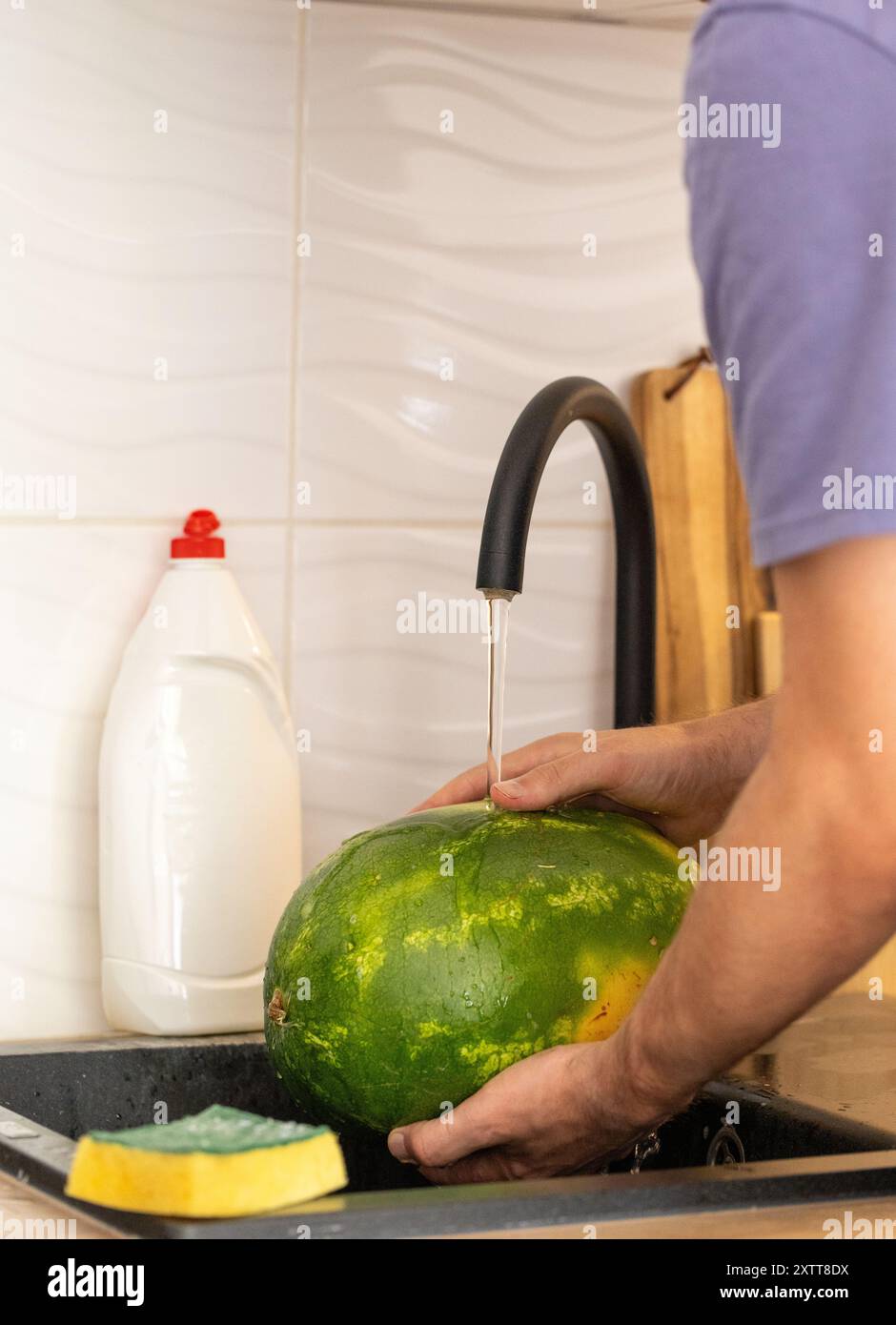 man washing watermelon in kitchen under running water, healthy eating ...