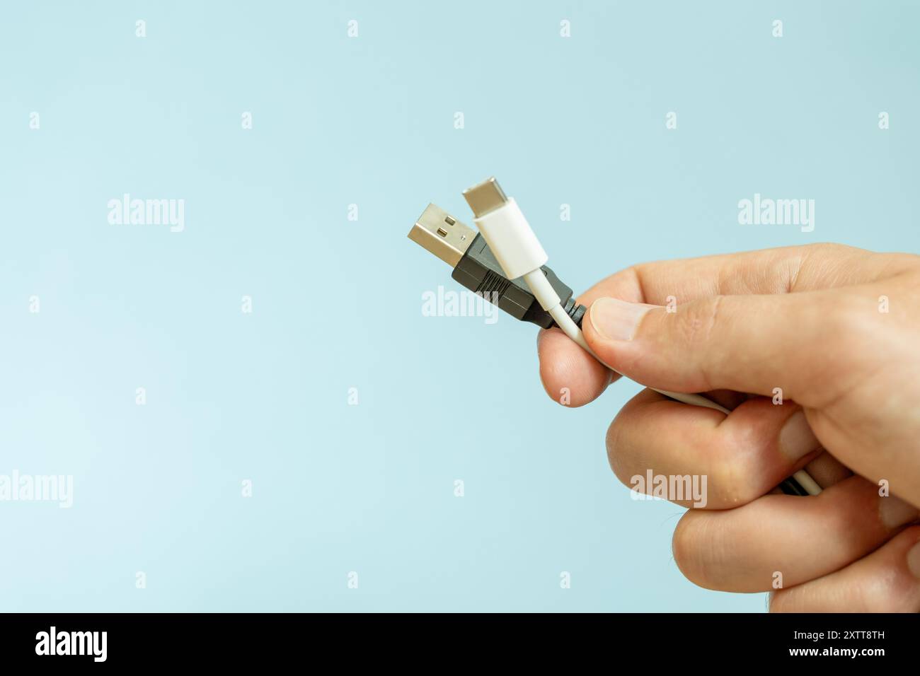 man holds several cables in hand, different types of USB cables ...