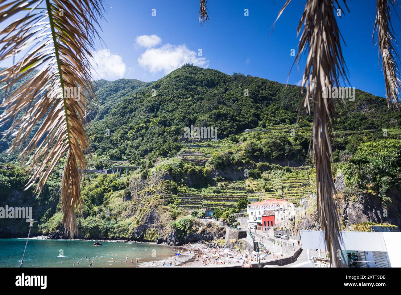 People enjoying the black volcanic sandy beach at Seixal on the North ...