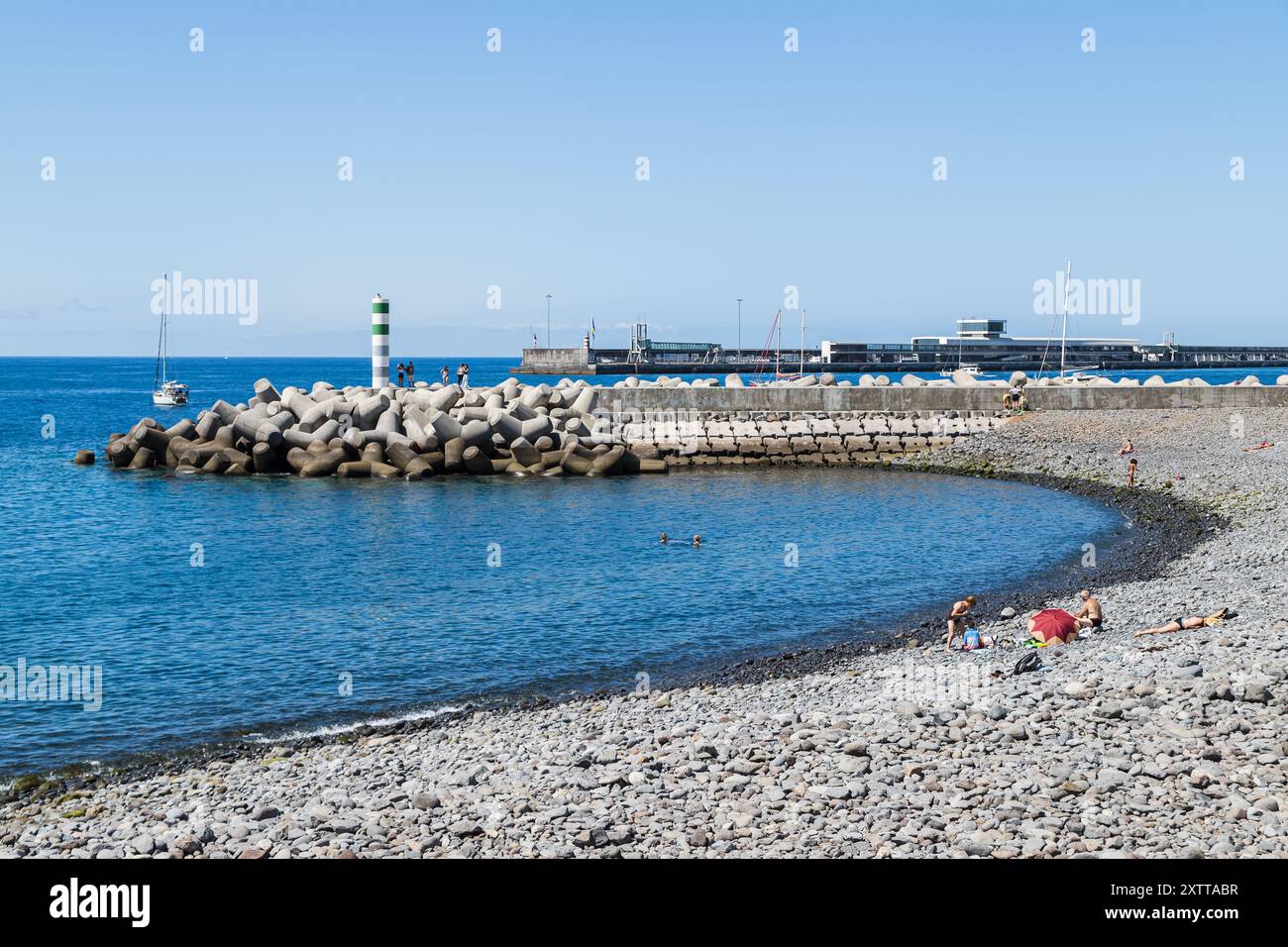 People enjoying and sunbathing in a small man made bay at Funchal ...