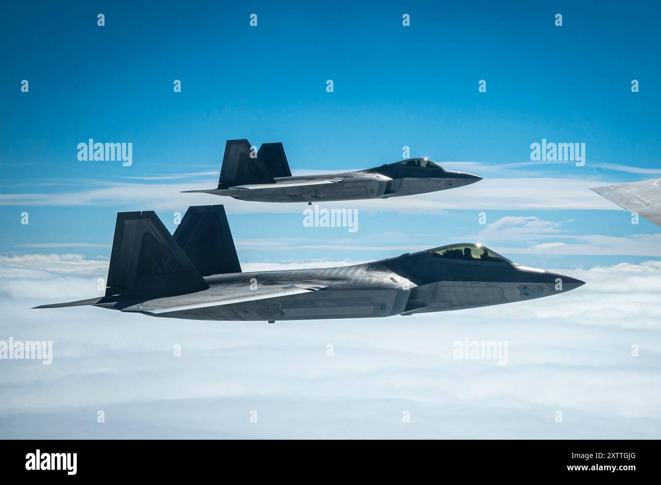 Two F-22 Raptors fly in formation with a KC-135 Stratotanker during ...