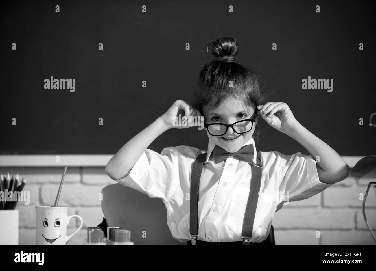 Cute child at school. Kid is learning in class on background of ...
