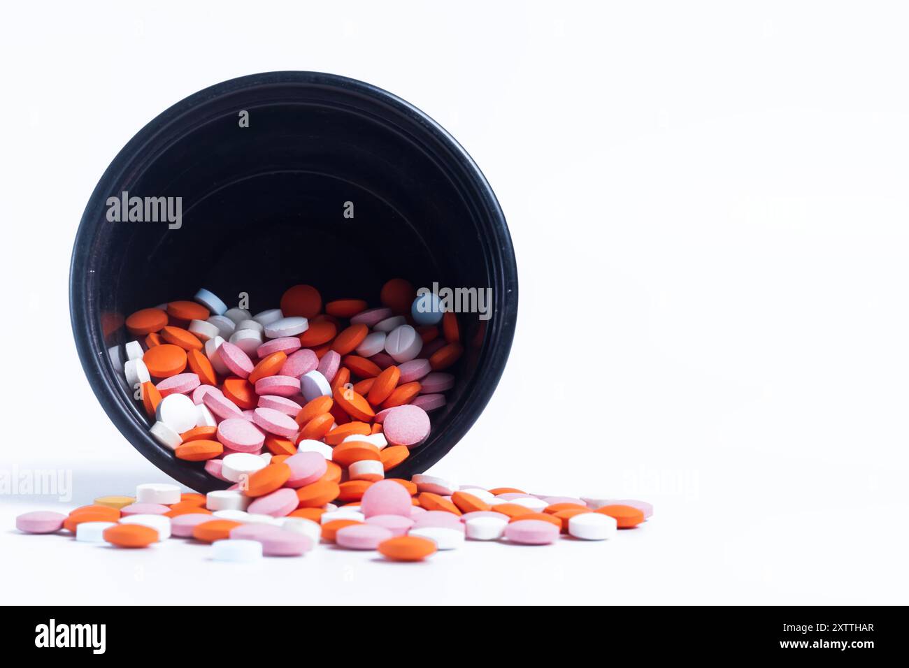 Multicolor pills spilling out of spilled from black plastic box on ...
