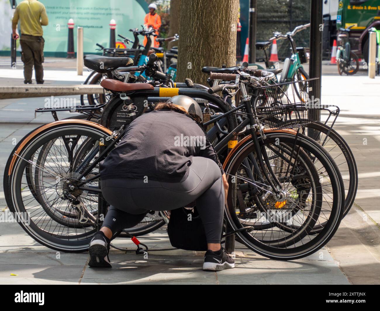 female cyclist locking up bicycle at designated bike rail in Central ...