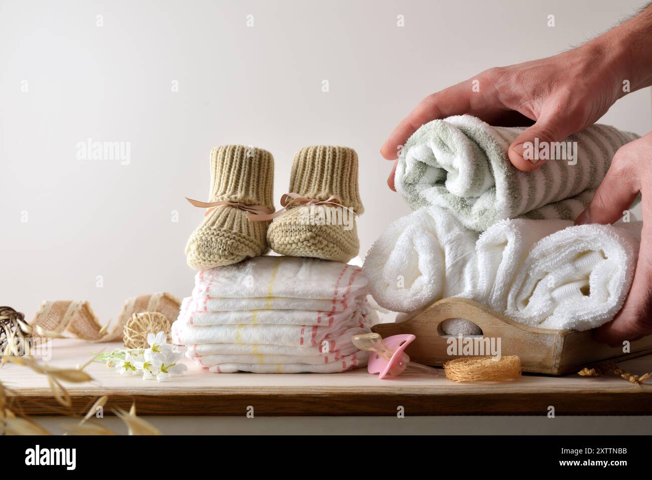 Hands preparing cloths and diapers for baby hygiene on wooden furniture ...