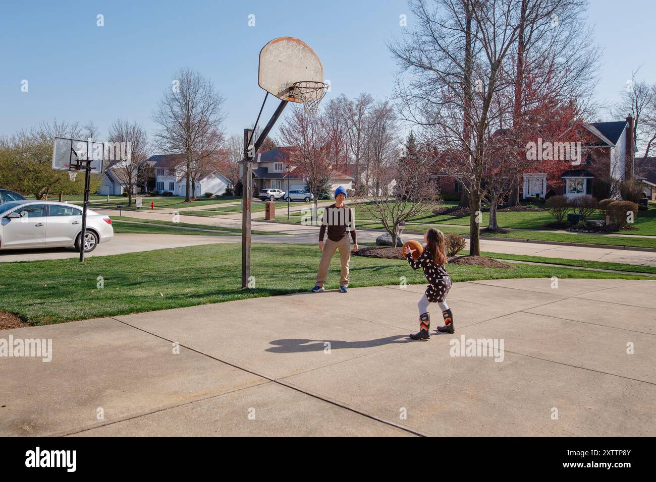 Father and daughter play basketball in driveway together Stock Photo ...