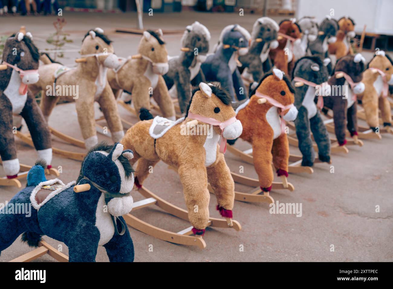 A row of wooden horse rocking horses are lined up on a sidewalk Stock ...