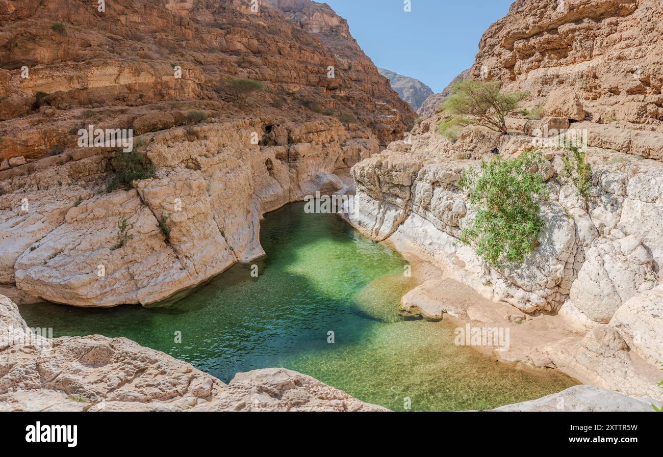 A pool in Wadi Ash Shab's gorge with a woman on a cliff, Oman. A must ...