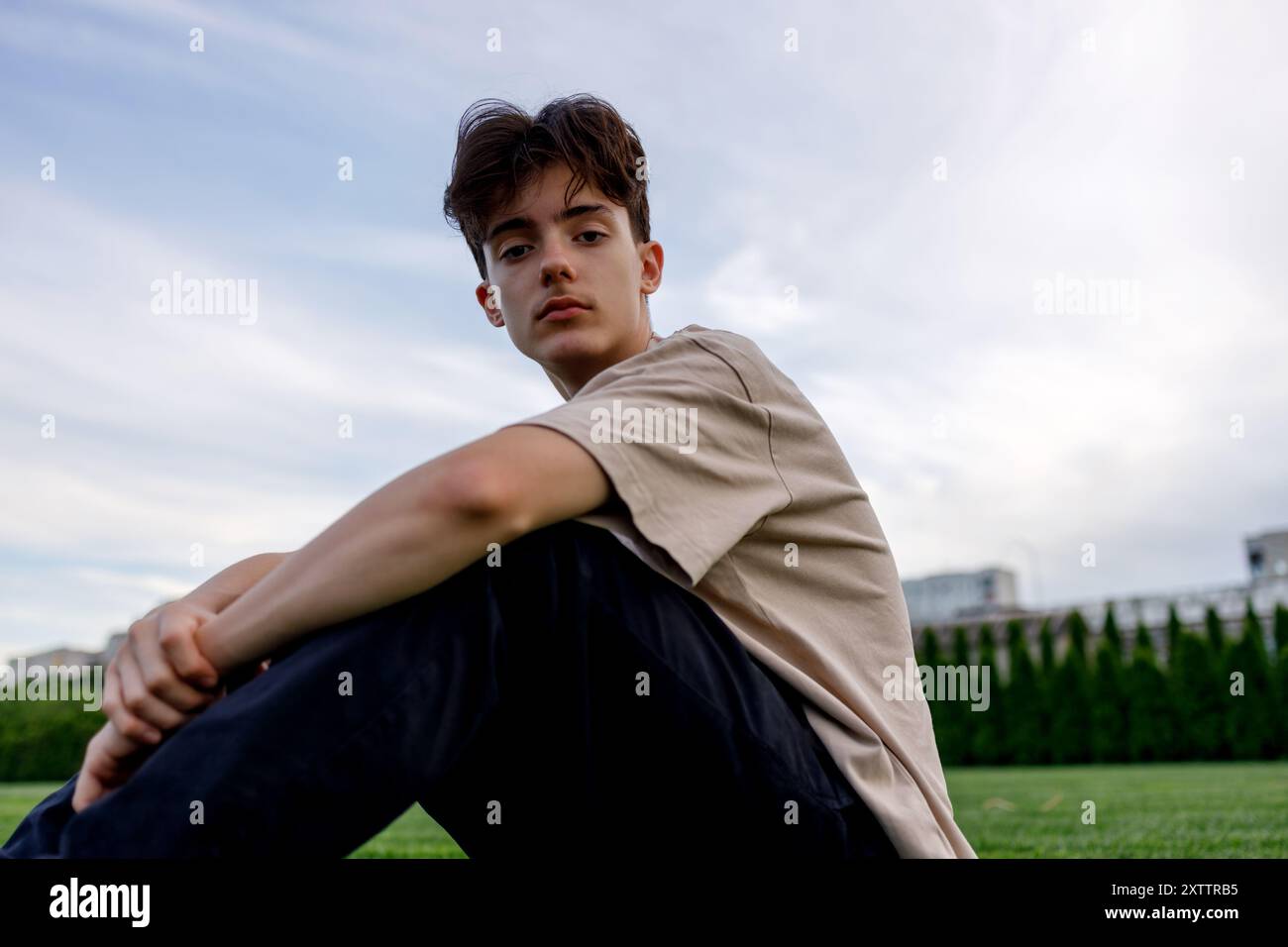 Teenager enjoying quiet time on the grass Stock Photo - Alamy