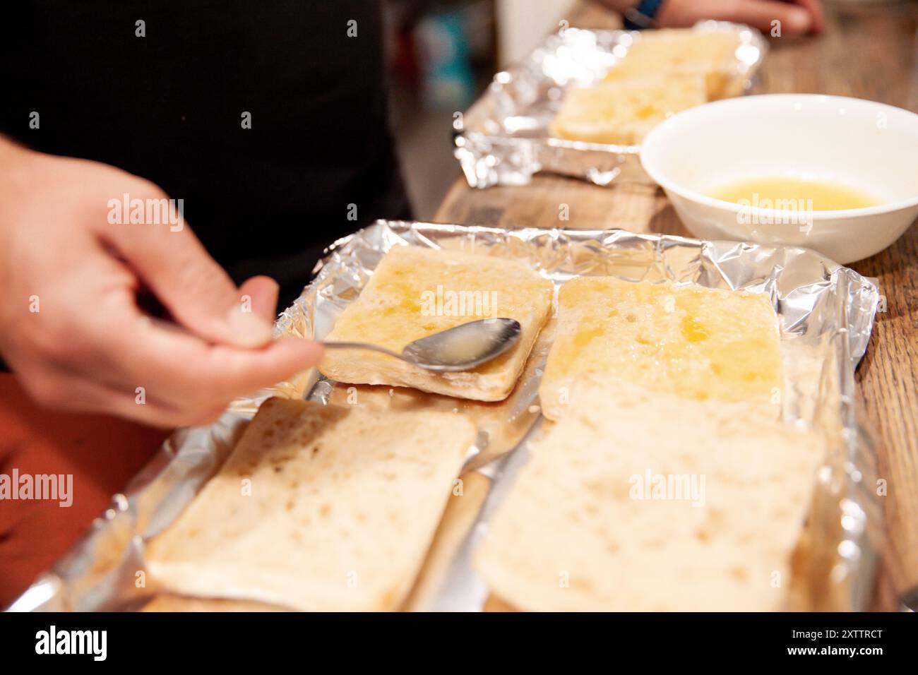 Person spreading melted butter on bread slices Stock Photo - Alamy