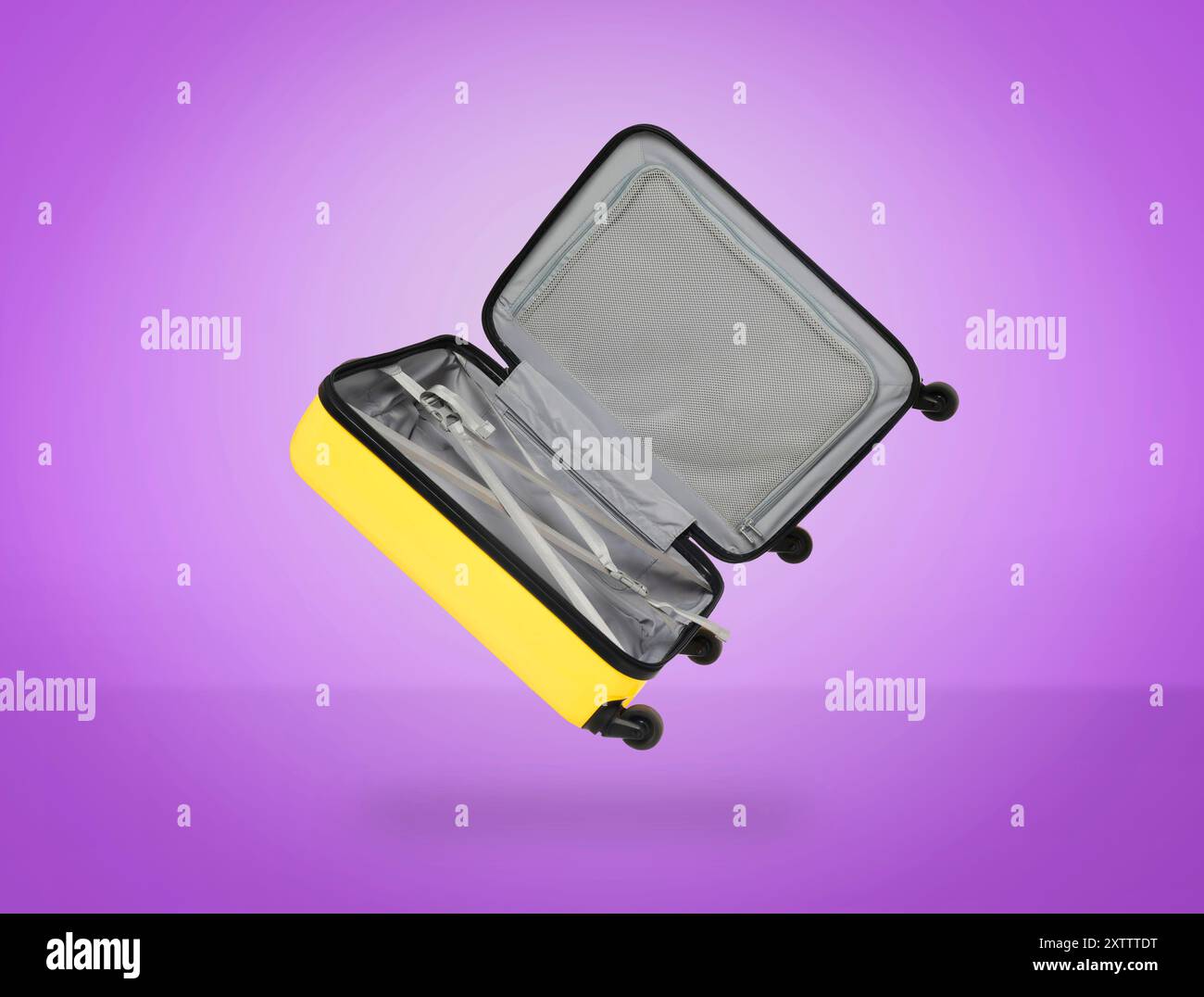 Open empty suitcase in air on violet background Stock Photo - Alamy