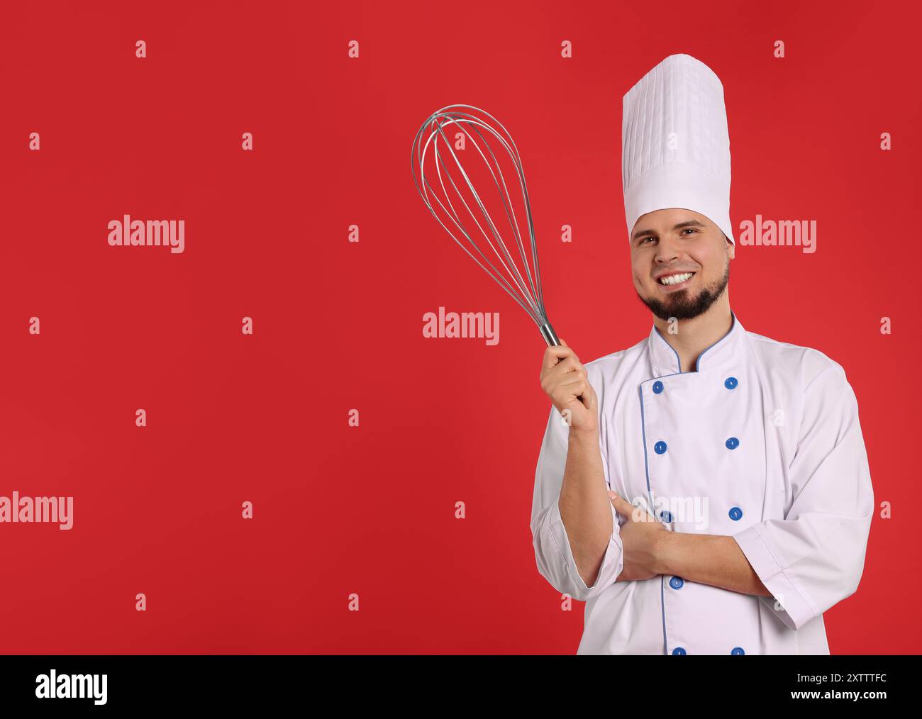 Happy pastry chef with big whisk on red background. Space for text ...