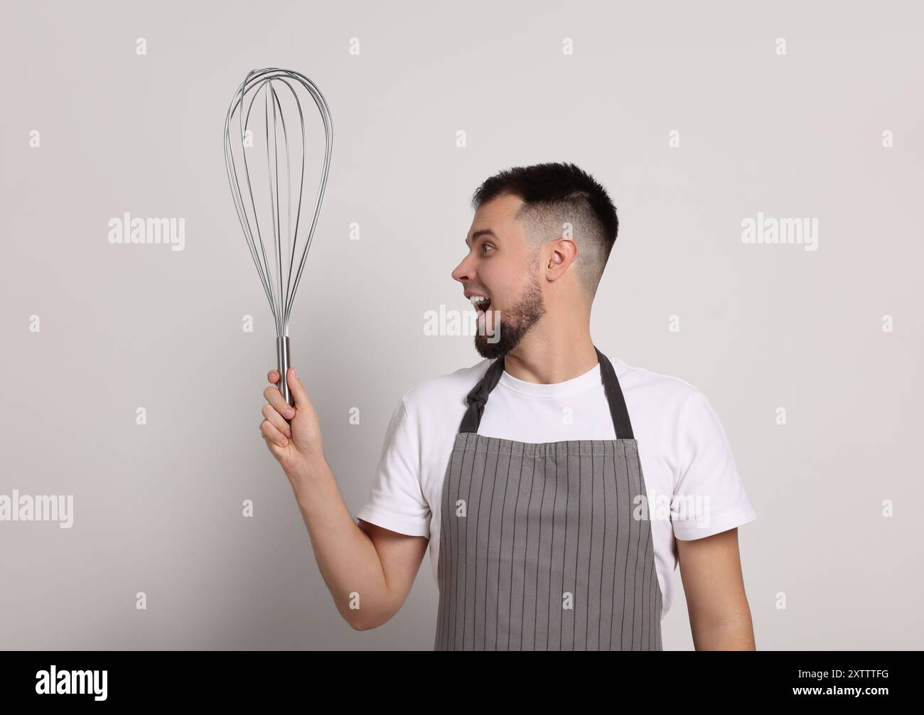 Emotional pastry chef with big whisk on light grey background Stock ...