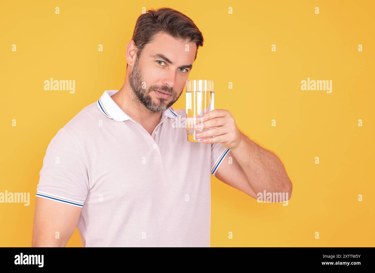 Man drinking water isolated on studio background. Portrait of man with ...