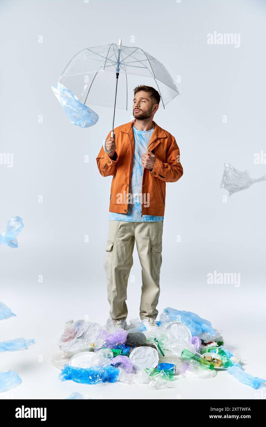 A man stands on a pile of plastic, holding an umbrella as plastic bags ...