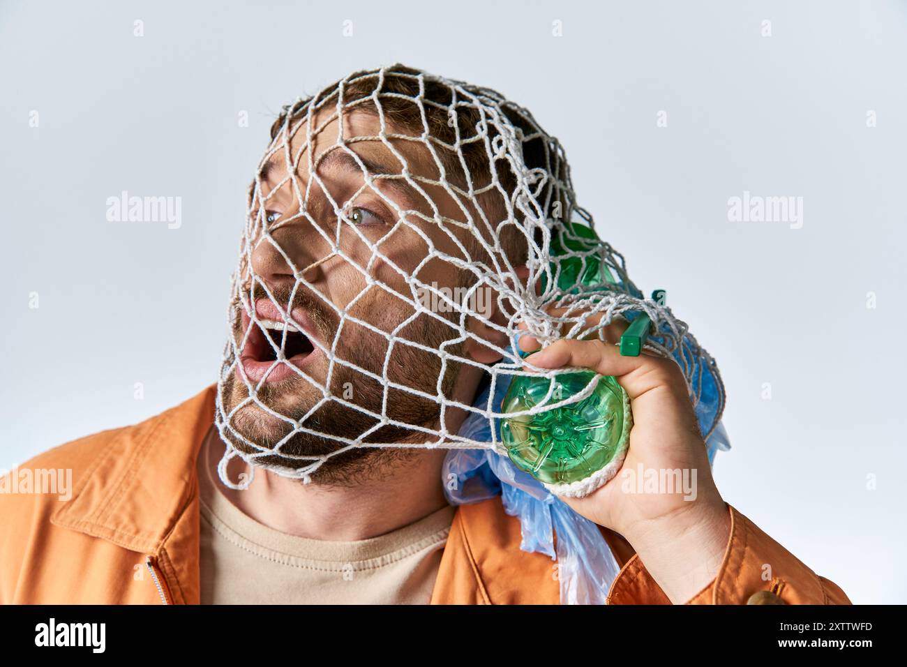 A man struggles with plastic waste, his face covered in a net Stock ...