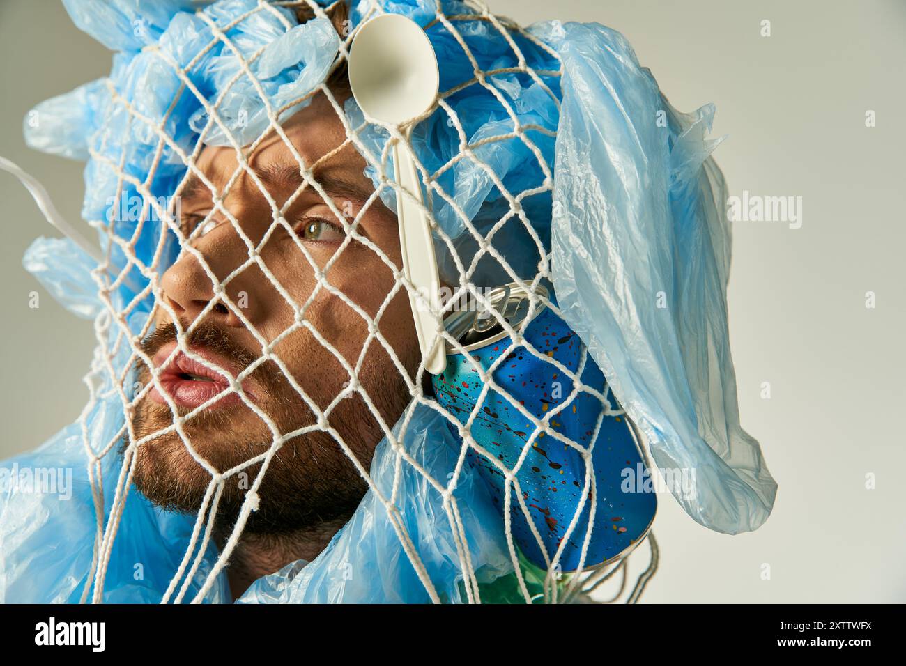 A man's face is obscured by a tangled mass of plastic bags and netting ...
