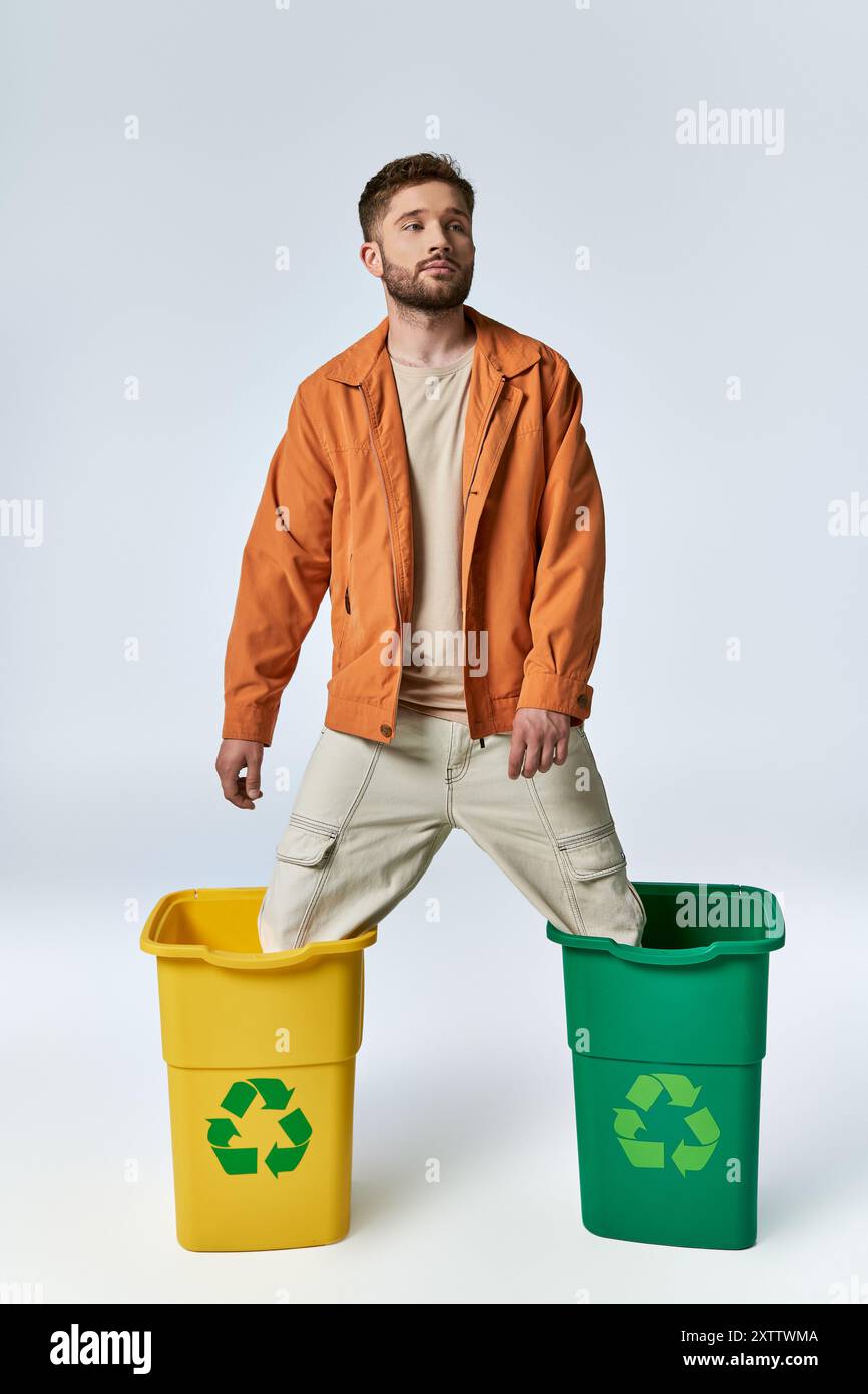 A man in an orange jacket is stuck with his legs in two recycling bins ...