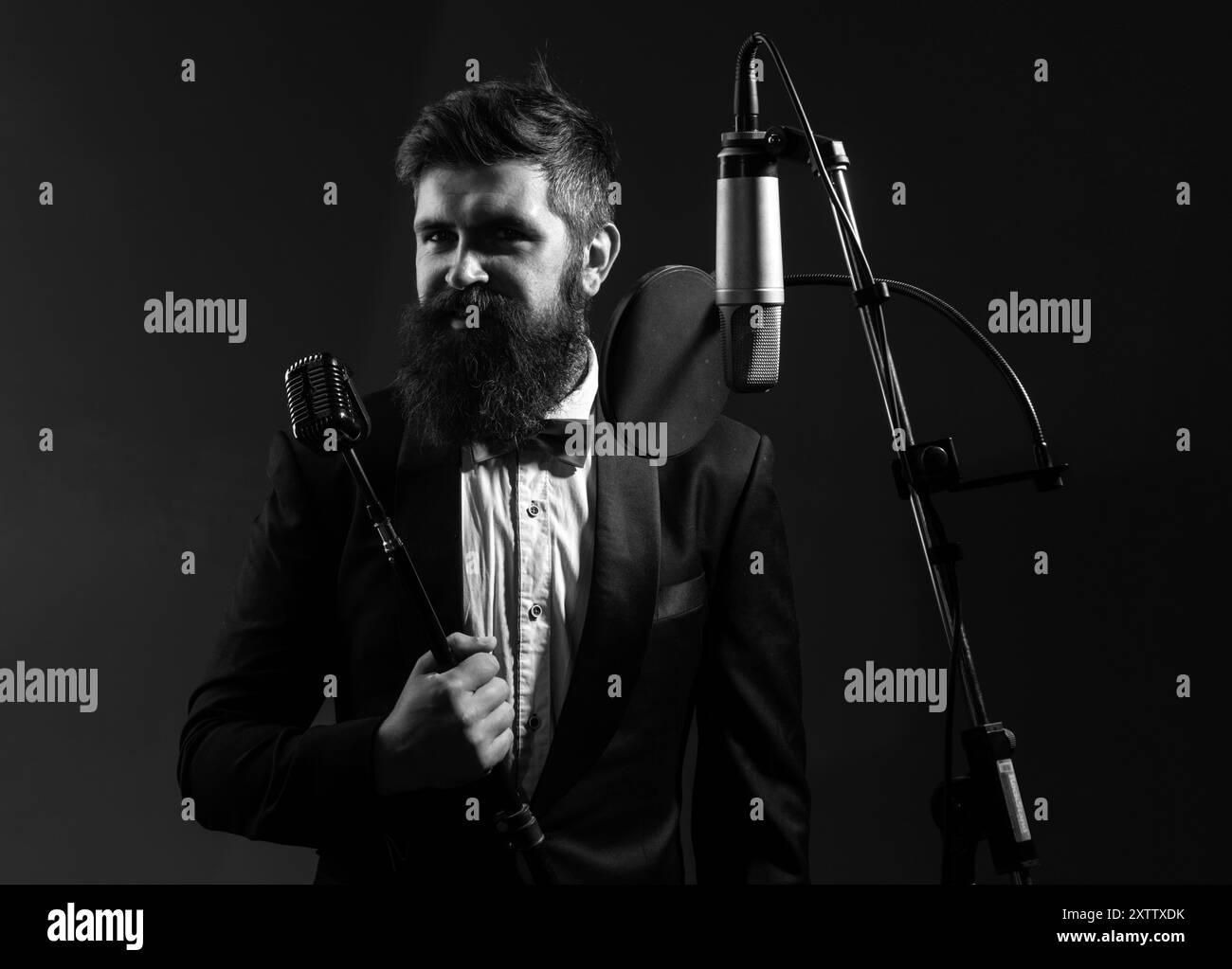 Portrait of singer in suit singing. Sound producer recording song in a ...