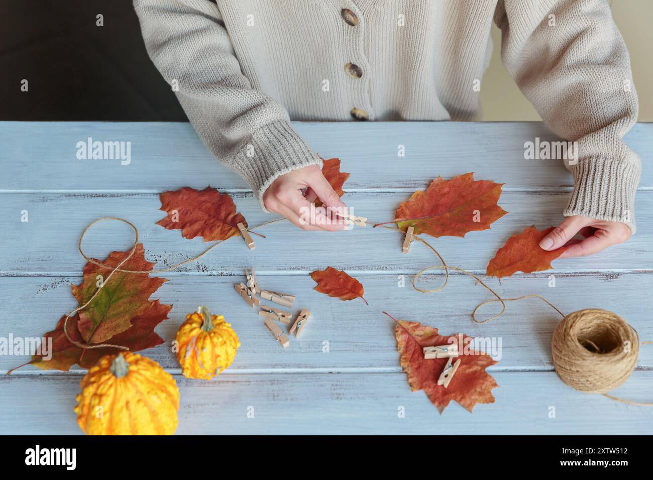 Homemade garland of colored autumn leaves with womans hands Stock Photo ...