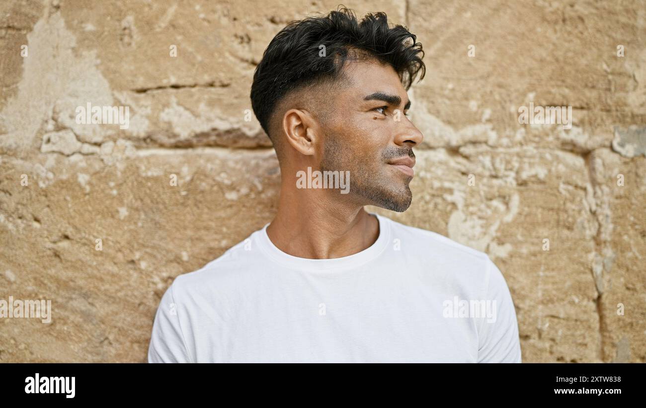 Handsome young hispanic man in profile with a casual white shirt posing ...