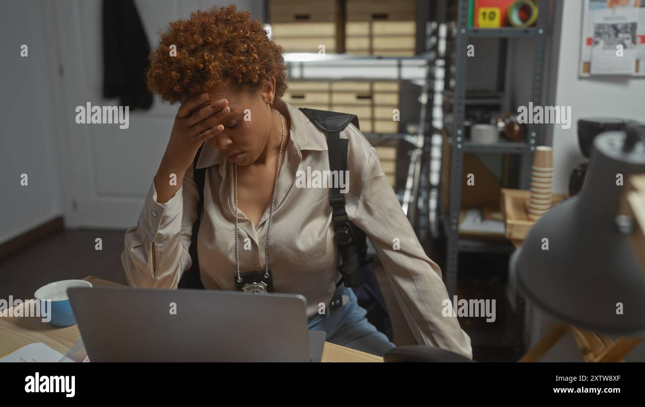 Stressed african american woman detective in office with laptop, badge ...