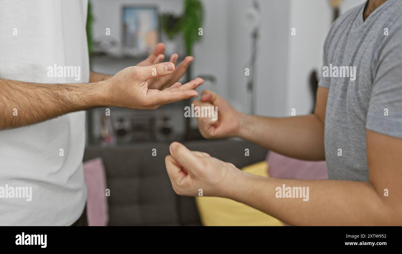 Two men engaging in a friendly hand gesture indoors, creating a sense ...