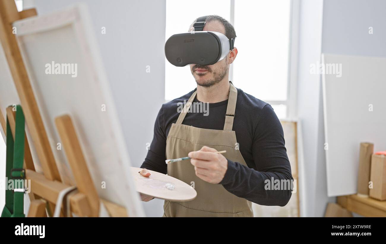 Man in apron using vr headset while painting on canvas in a bright studio interior Stock Photo ...