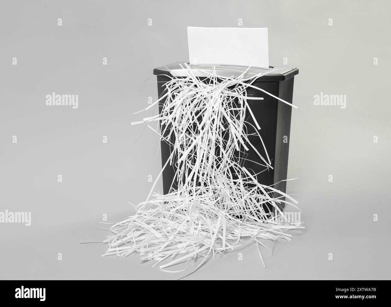 Destroying sheet of paper with shredder on light grey background, space ...