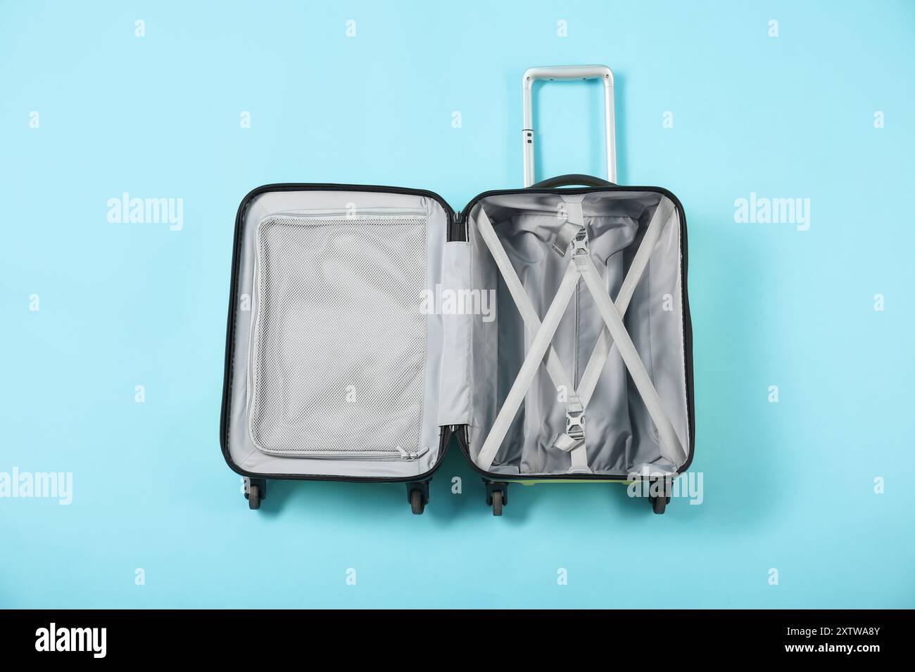 Open empty suitcase for travelling on light blue background, top view ...