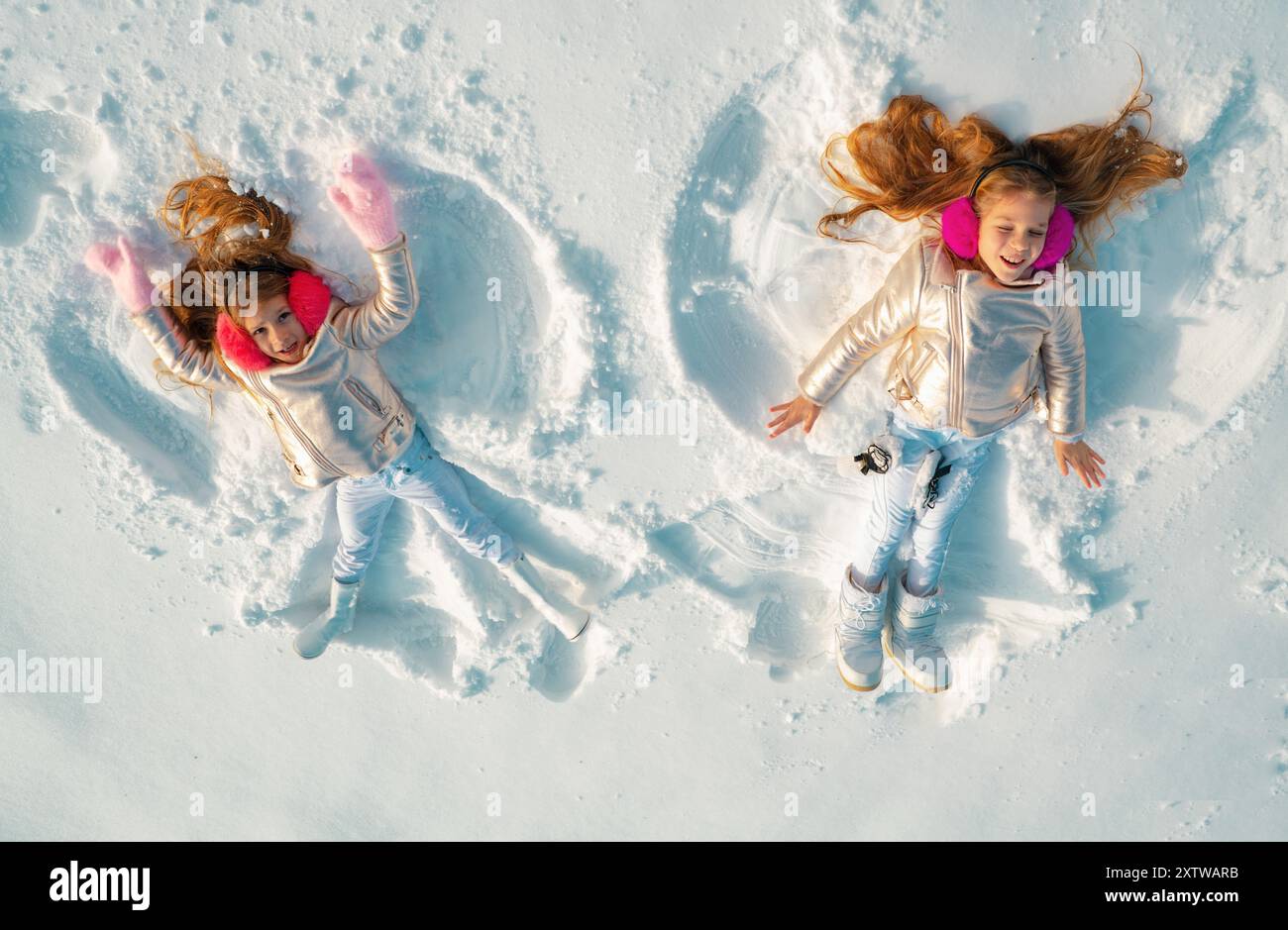 Snow angels made by a kids in the snow. Smiling children lying on snow ...