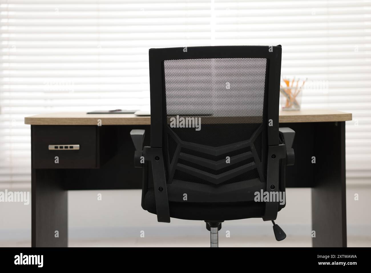 Black chair, laptop and desk in office Stock Photo - Alamy
