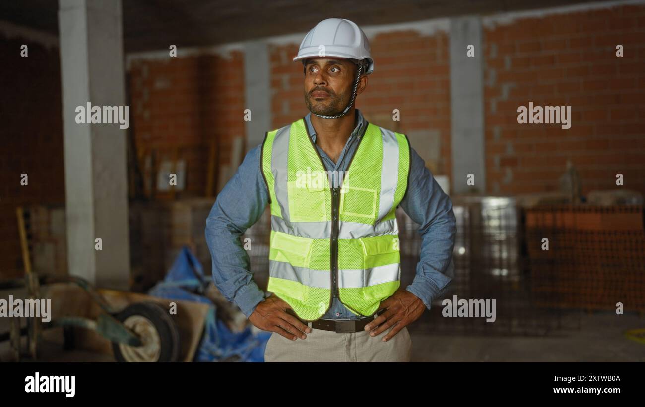 Handsome, young, african, american, man wearing a safety vest and helmet stands confidently at a ...