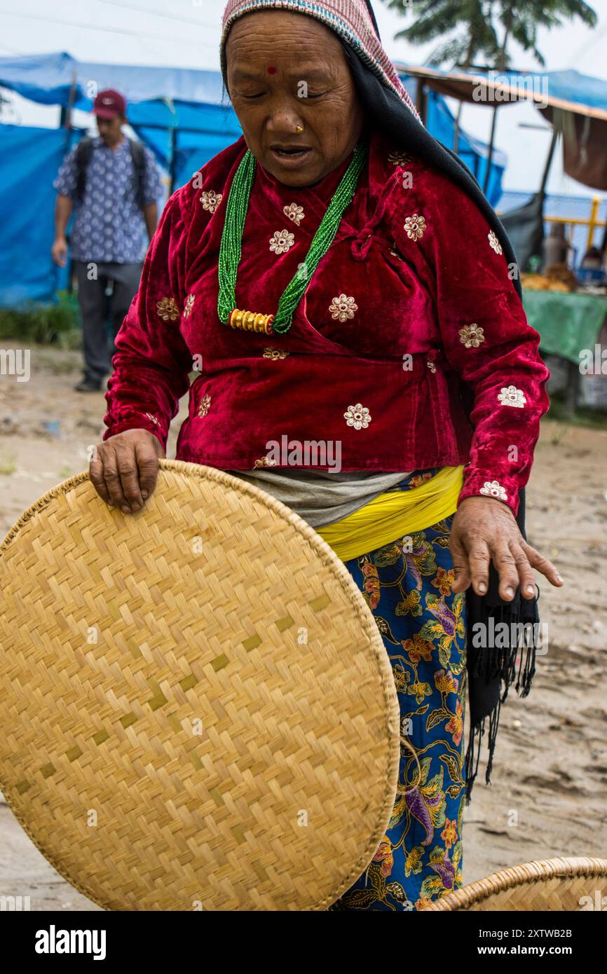 A woman checks out Nanglo, a wicker tray at a Haat Bazaar in Khandbari ...