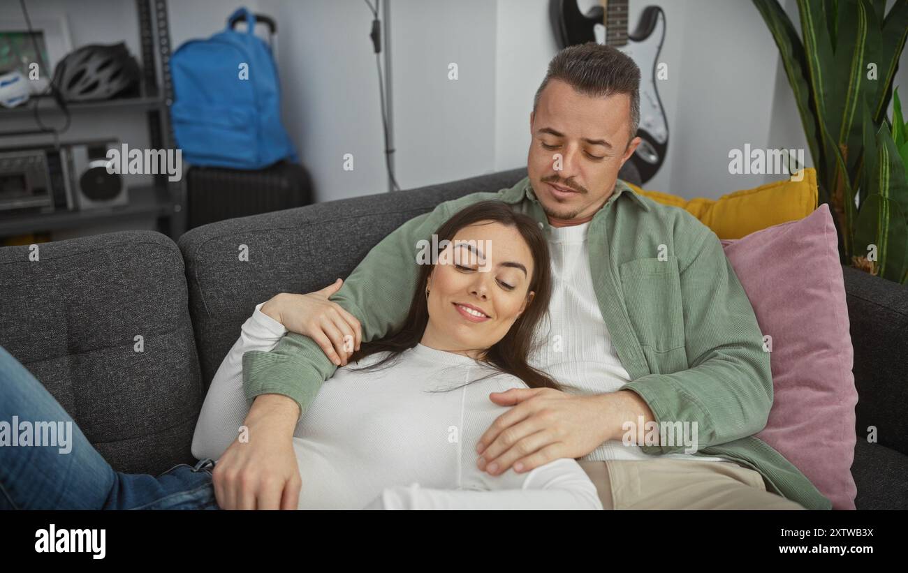 A woman and man relax together on a sofa in a cozy living room ...