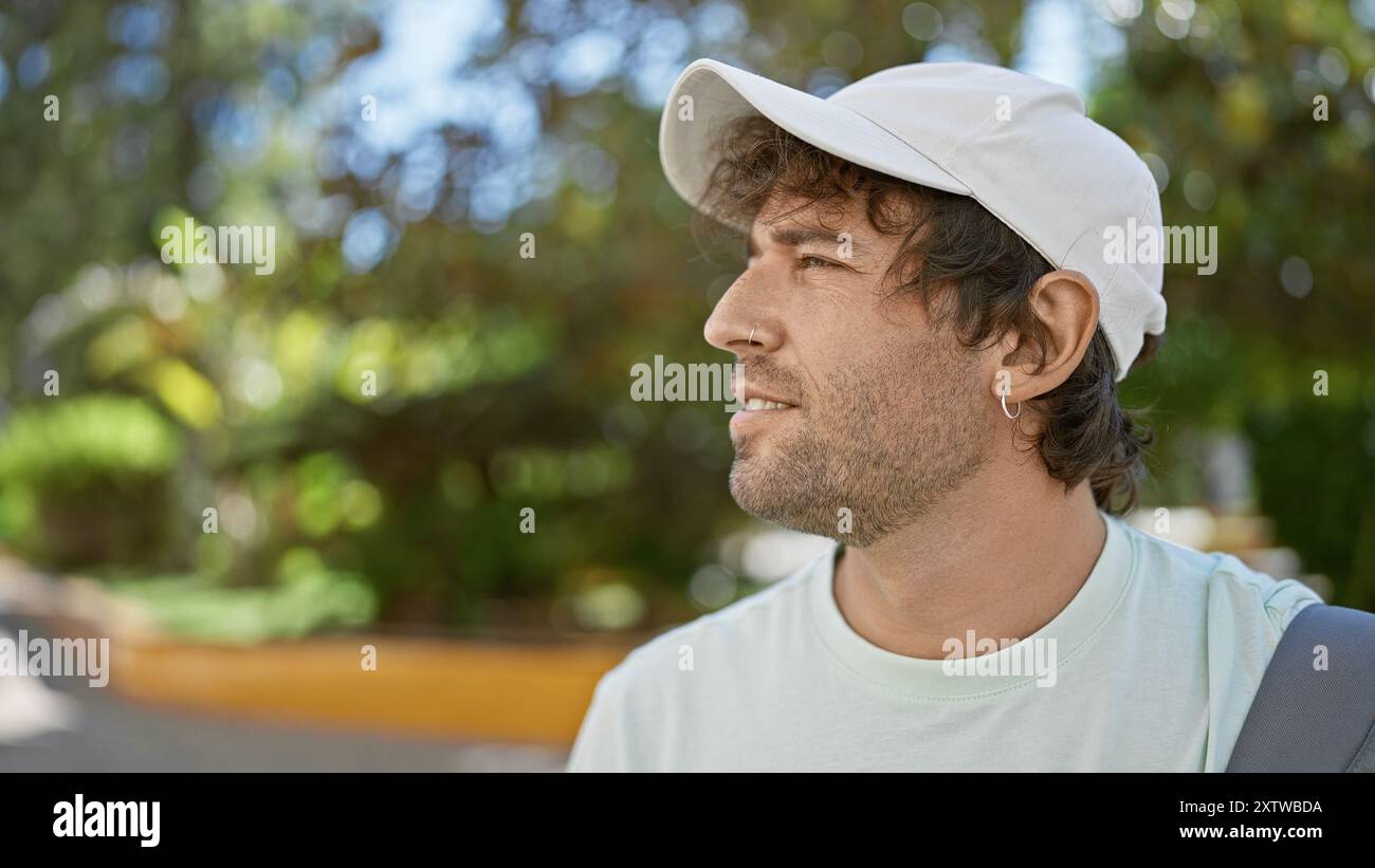 Handsome hispanic man with beard and green eyes wearing cap, looks ...