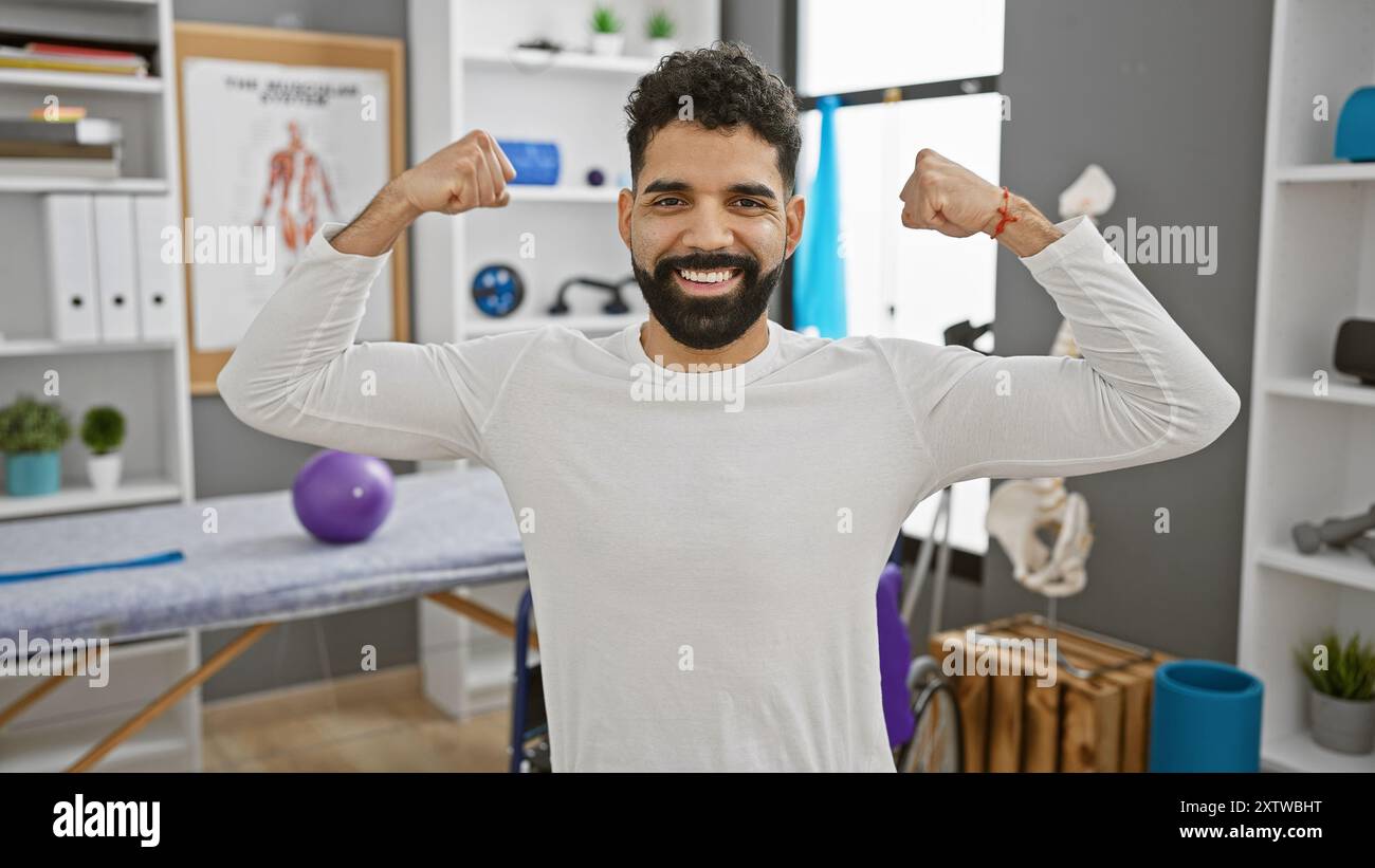 Handsome young hispanic man flexing muscles joyfully in a modern ...