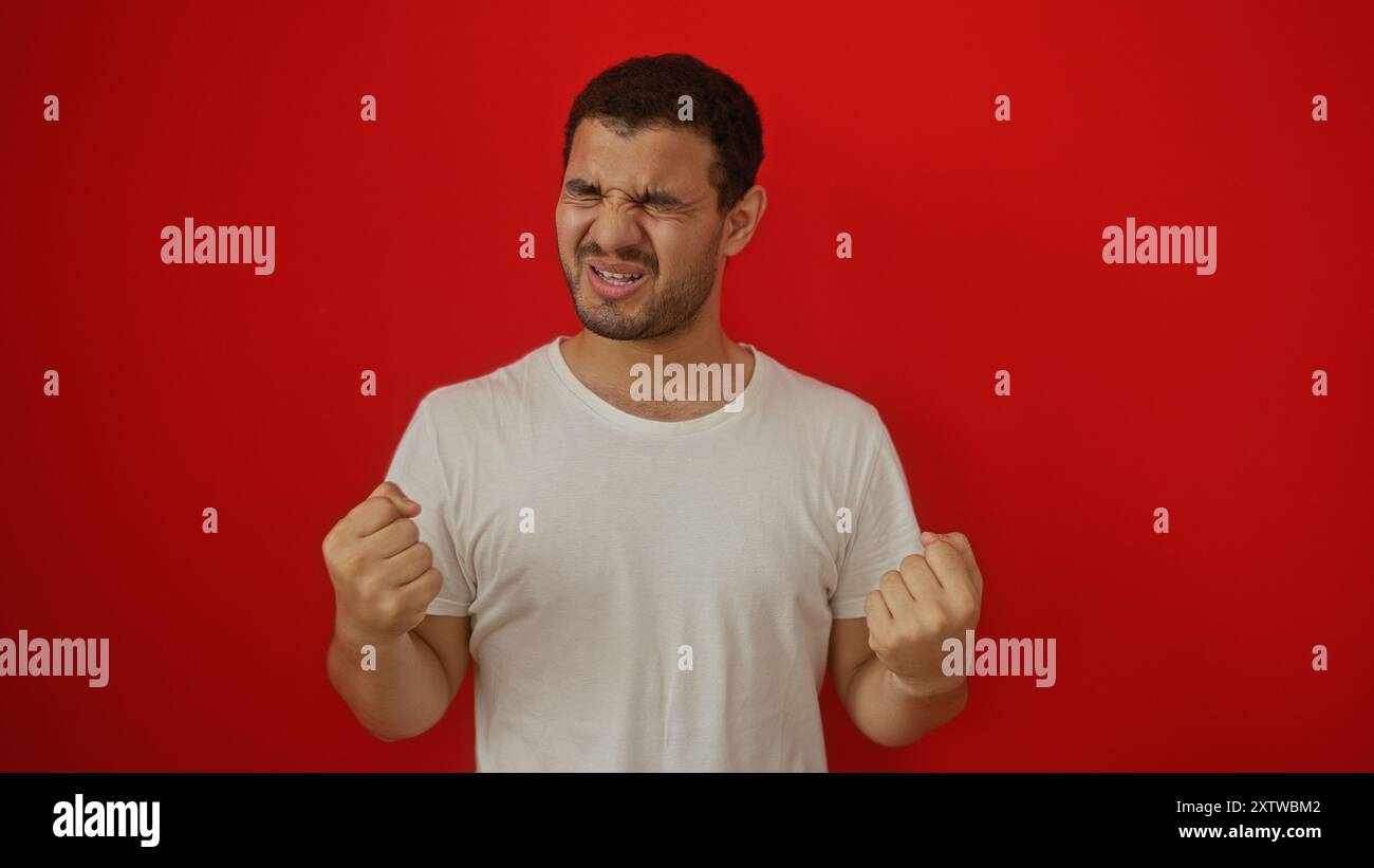 Hispanic man in a white shirt expressing excitement against a bright ...