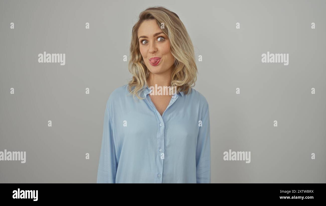 A playful young woman sticking out her tongue, isolated on a white ...