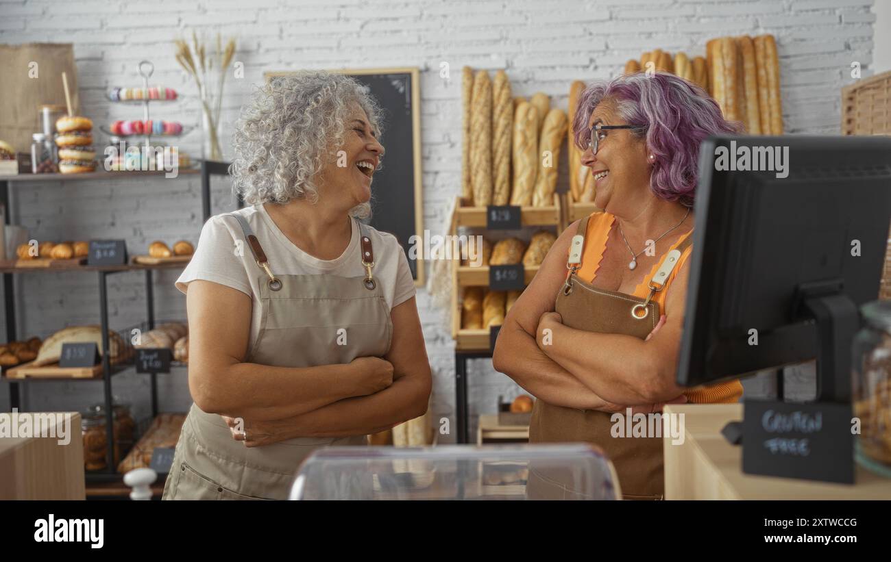 Women bakers laughing and standing with arms crossed in a bakery ...