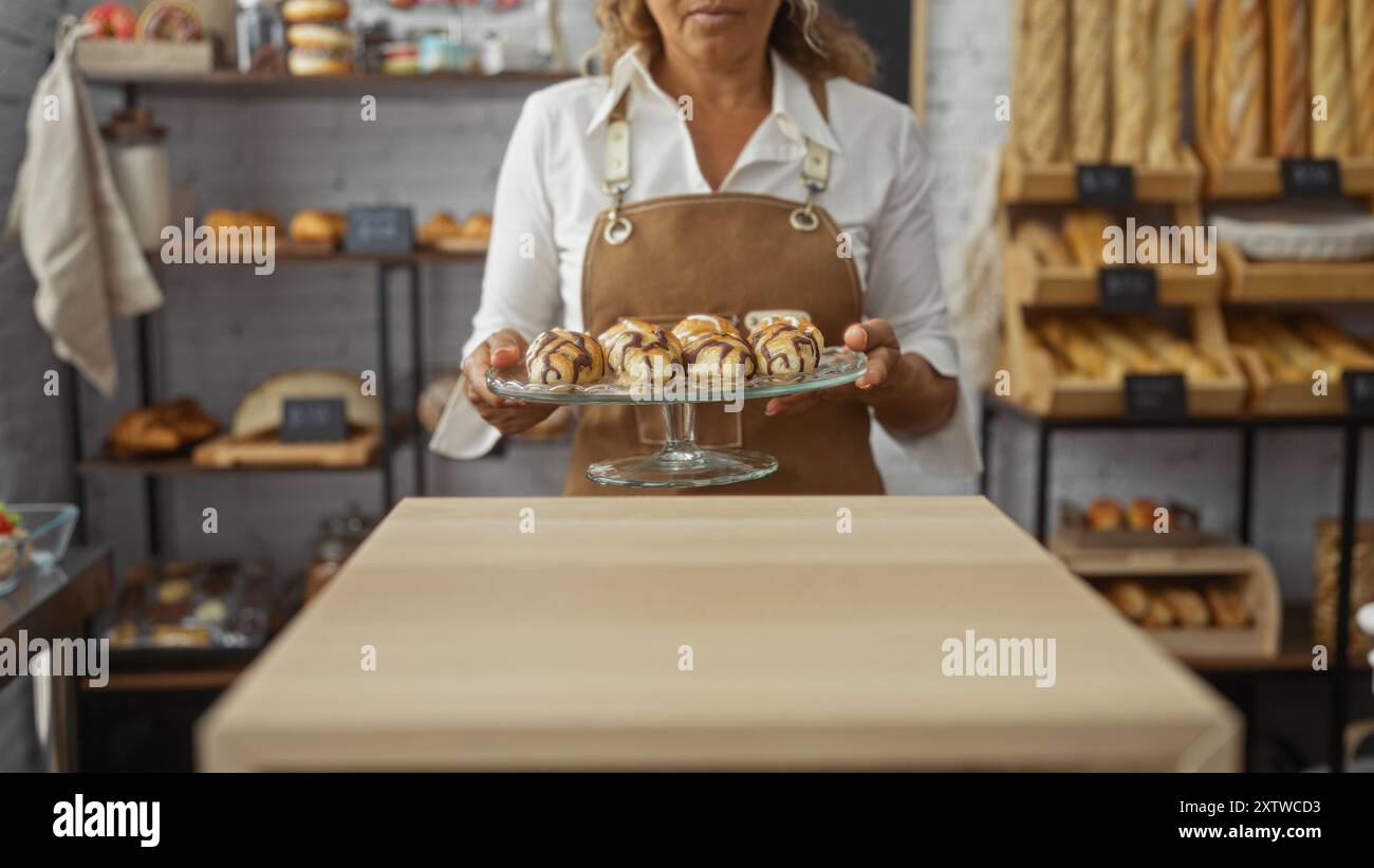 Woman holding baked pastries on a tray in a bakery with bread and ...