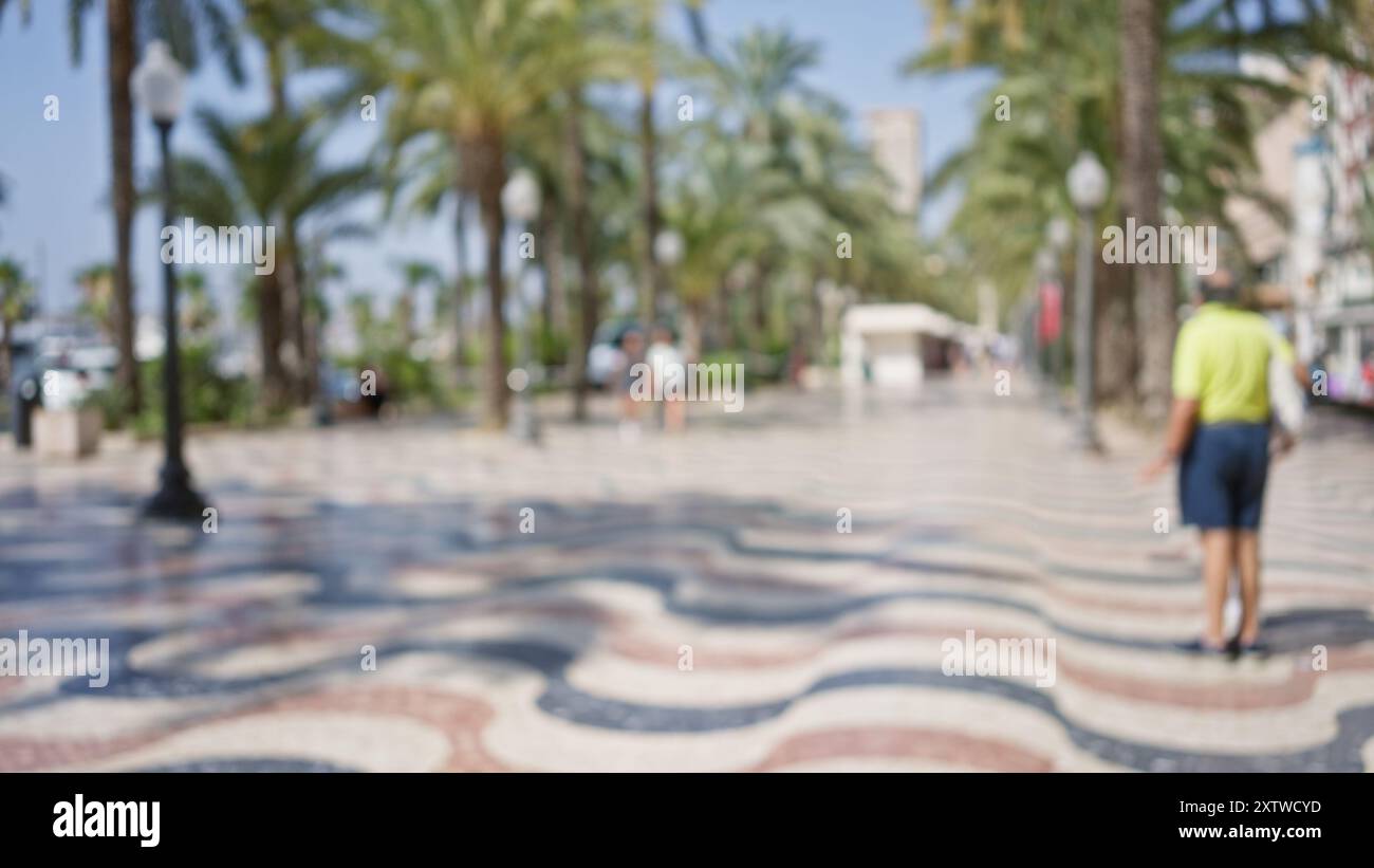 Blurred view of the outdoor promenade in alicante, spain with people in ...